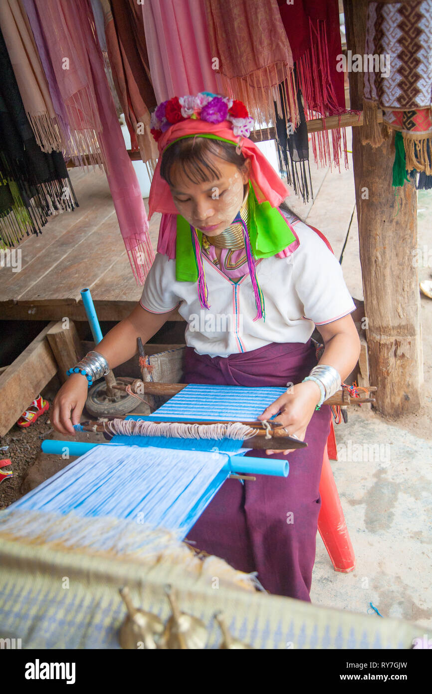 Kayan woman in traditional clothing weaving by hand fabric on a hand ...