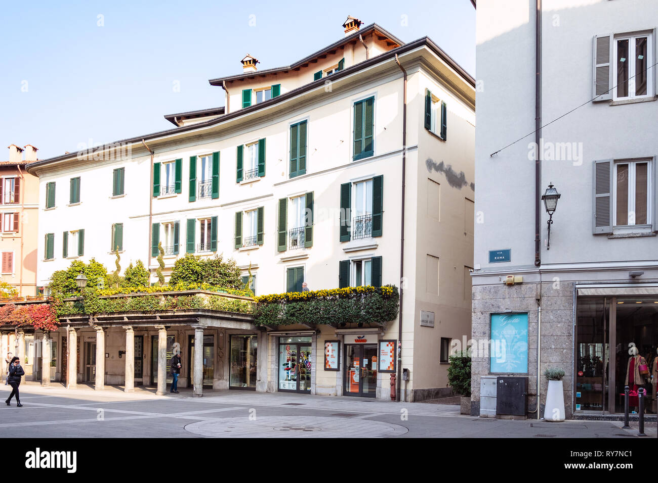 LECCO, ITALY - FEBRUARY 20, 2019: people near apartment houses on ...