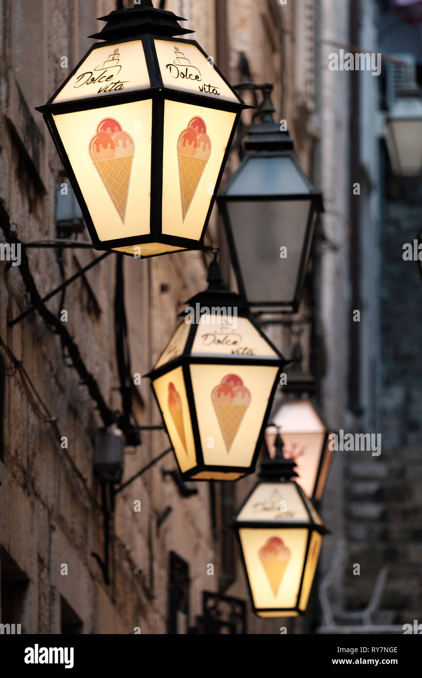 Vintage street lamps advertising an ice cream parlour in the side ...
