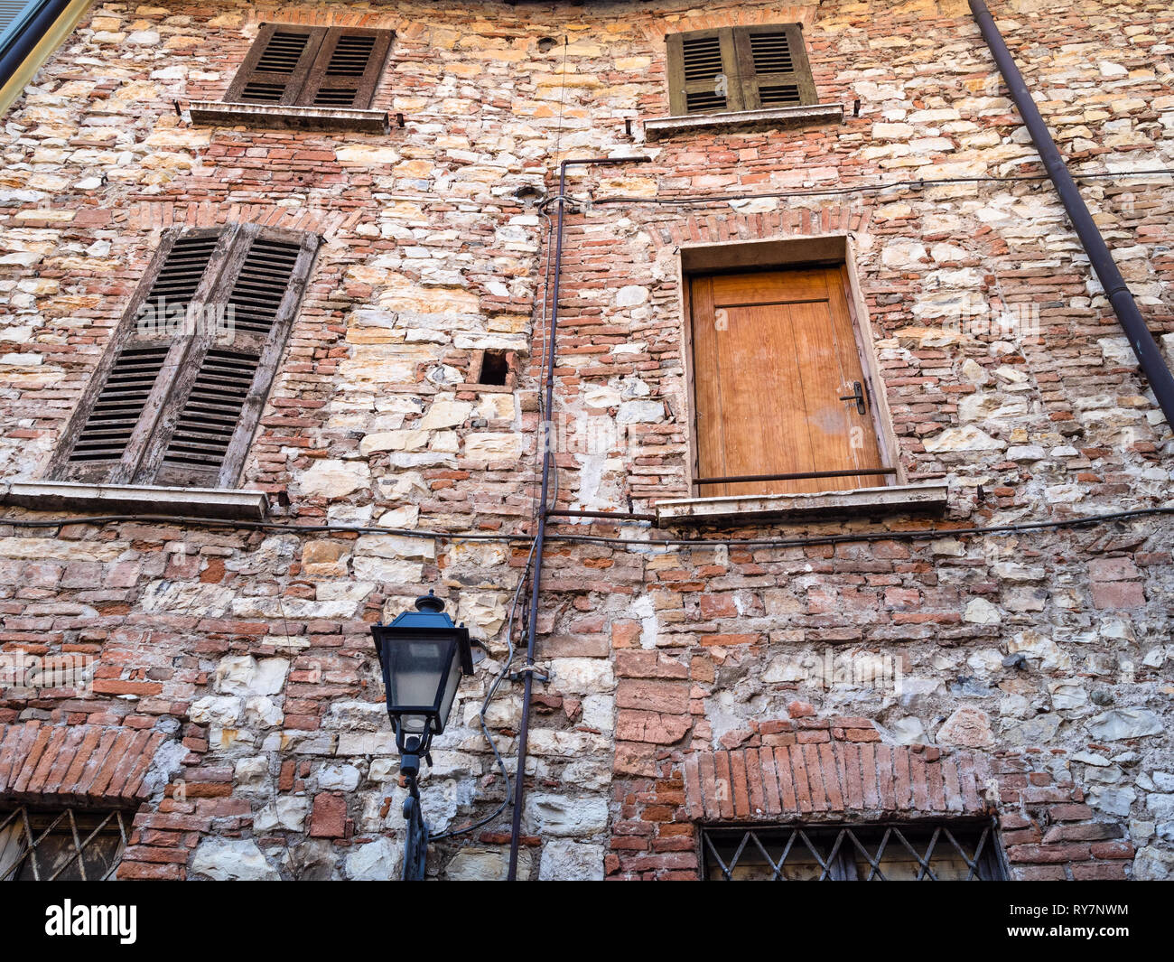 Travel to Italy - facade of shabby medieval brick house on street ...