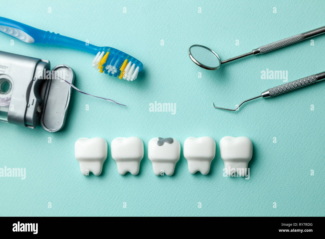 Healthy white teeth and tooth with caries on green mint background ...