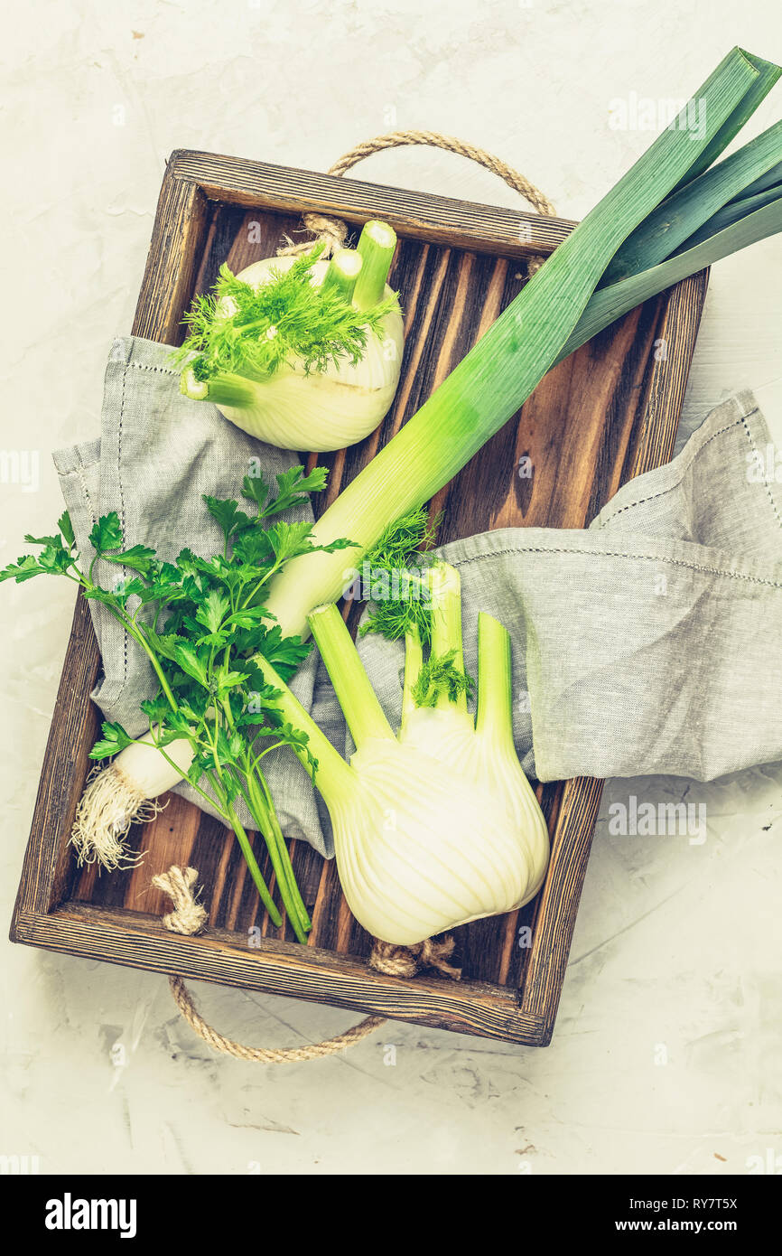 Fresh Florence fennel bulbs or Fennel bulb, leek and parsley in wooden ...