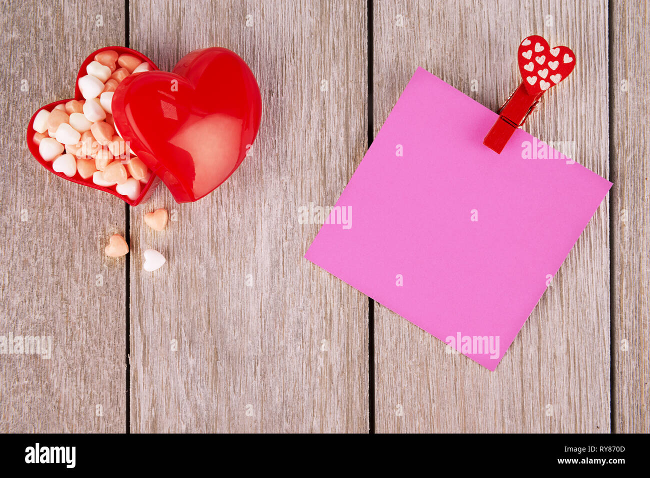Pink paper notepad on white wooden plank in background. Copy space for ...