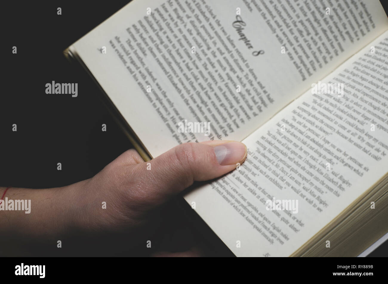 Men's hand holds an open book ready for reading. Closeup Stock Photo ...