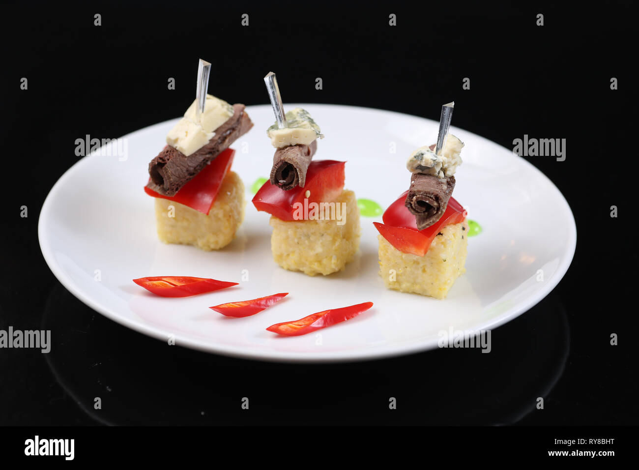 sliced meat, rolled into a roll, canapes with blue cheese and red ...