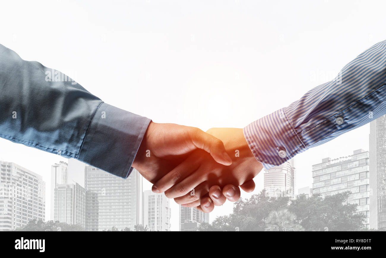 Business handshake as idea for unity and cooperation or greeting. Mixed ...