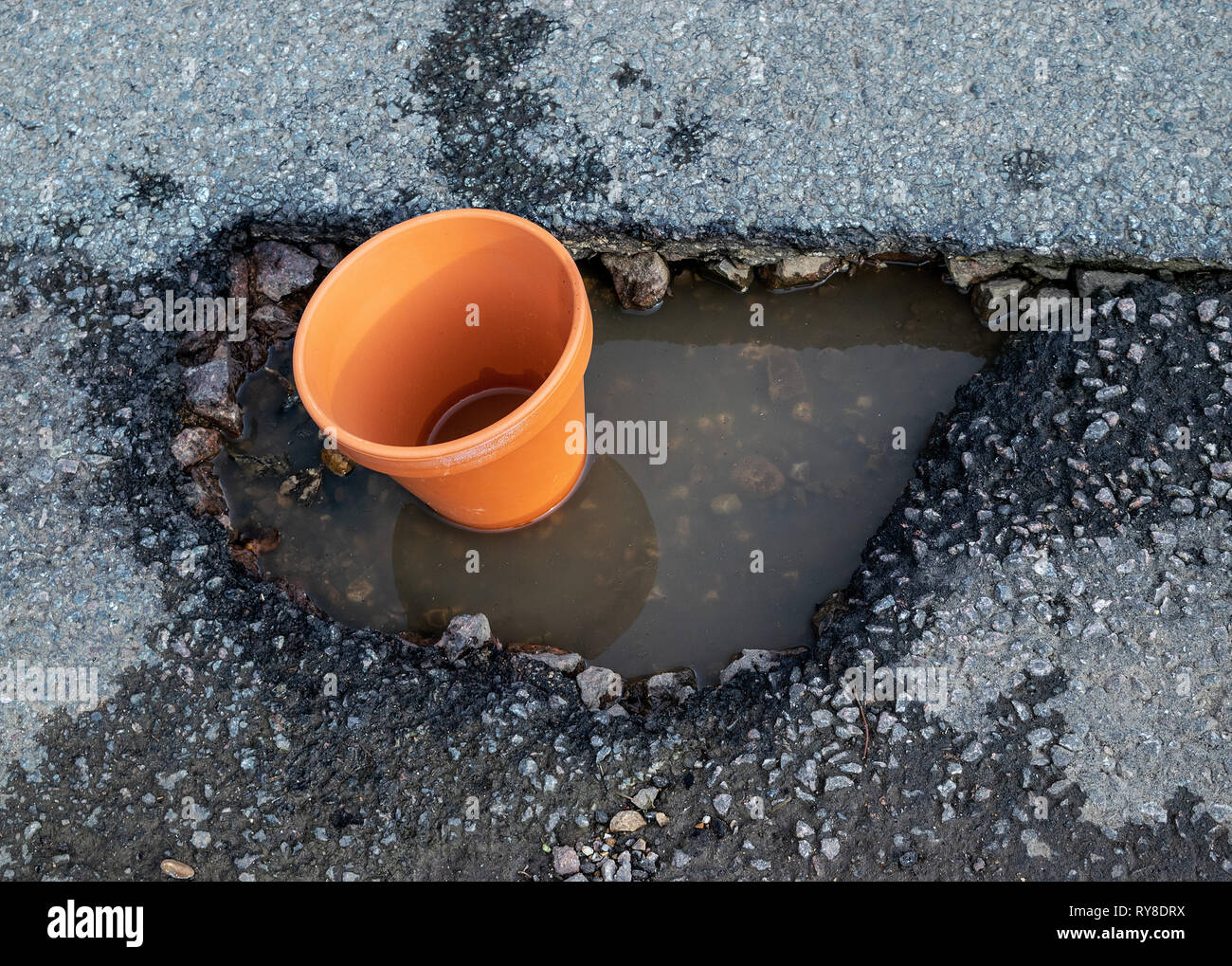 Large flower Pot in a Large Pothole Stock Photo - Alamy