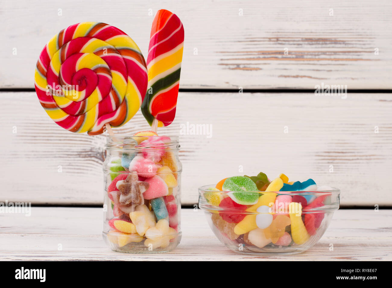 Composition of delicious candies on wooden background Stock Photo - Alamy