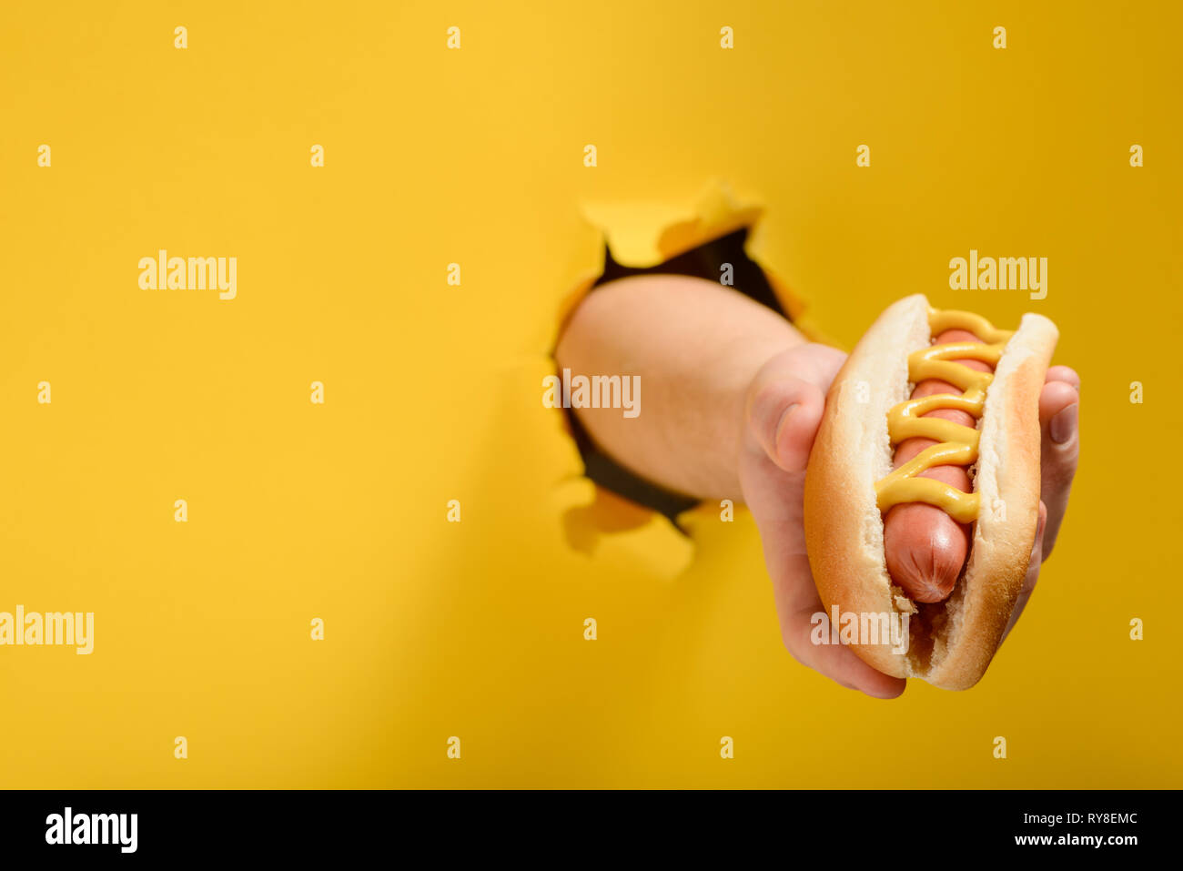 Hand giving a hot dog Stock Photo - Alamy