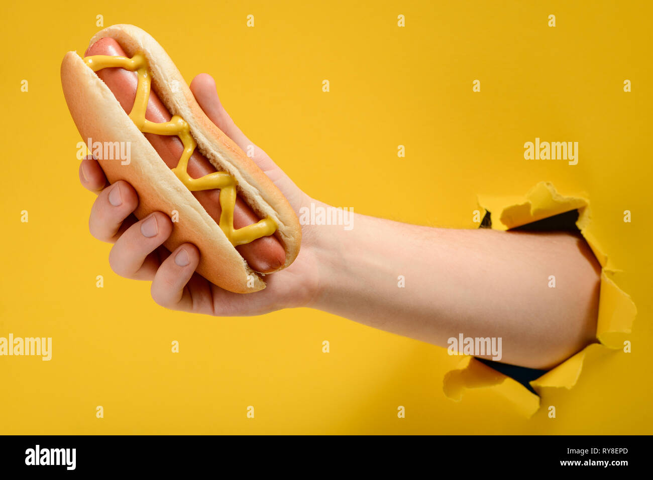 Hand taking a traditional hotdog Stock Photo - Alamy
