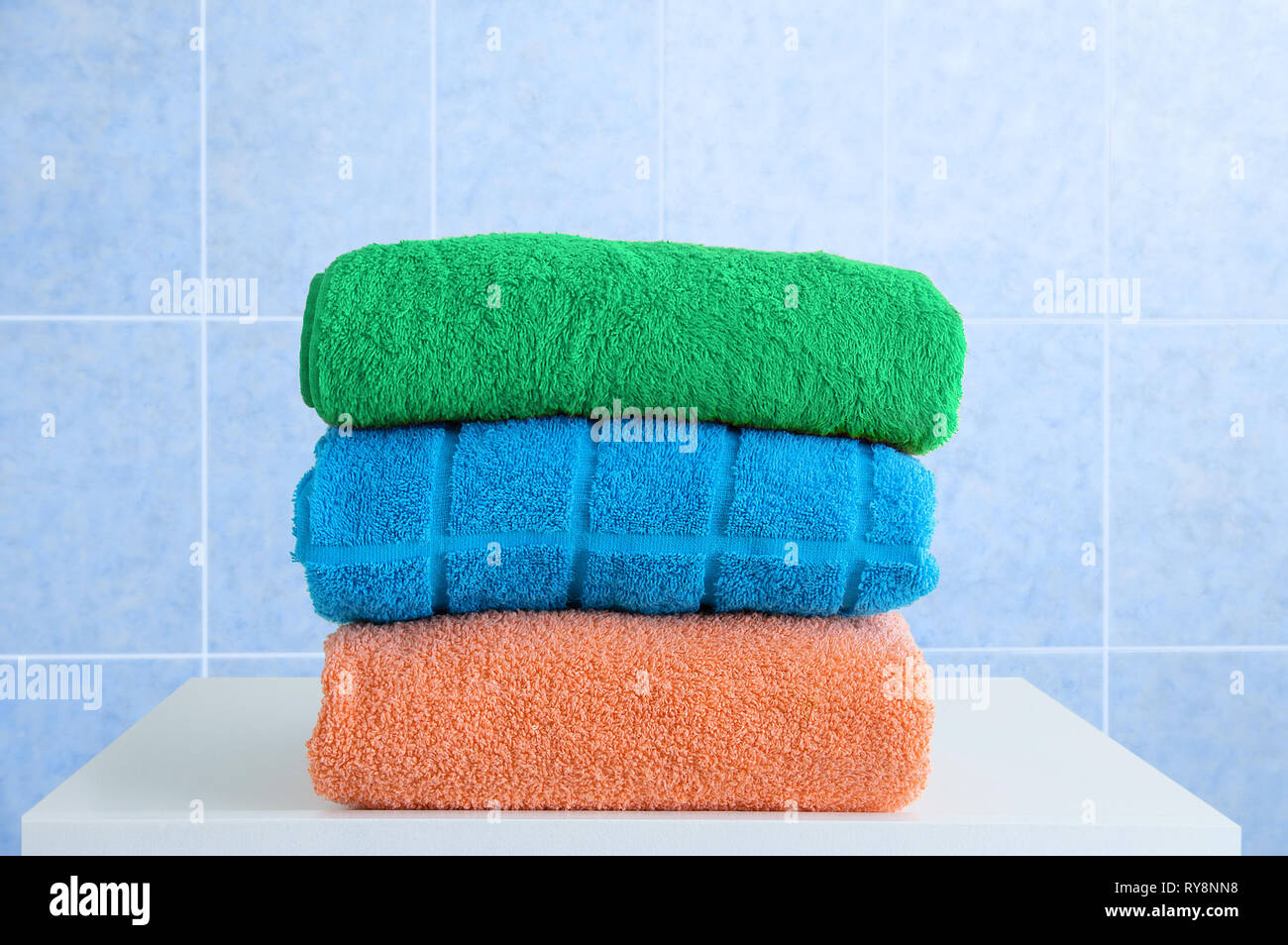 Terry towels on a white nightstand in the bathroom. Background blue ...