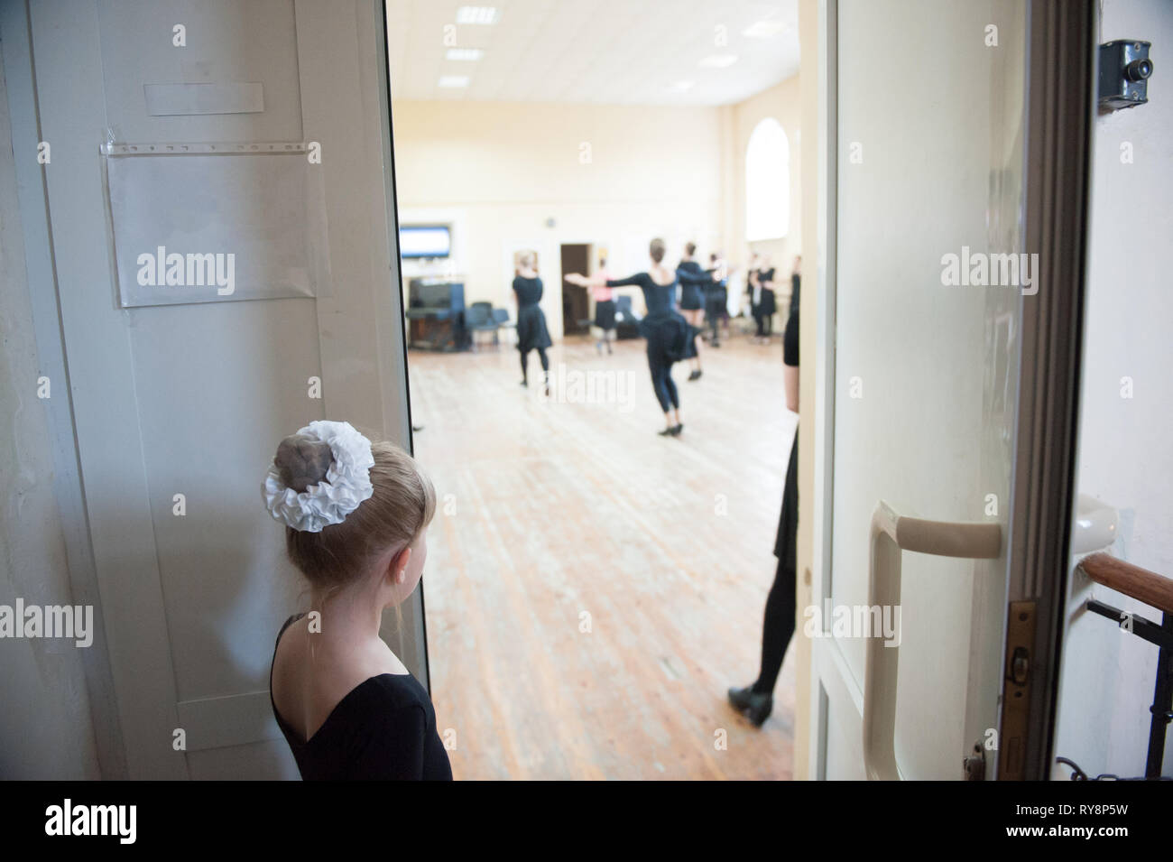 little russian ballerina looking through open doorway on dancing ...