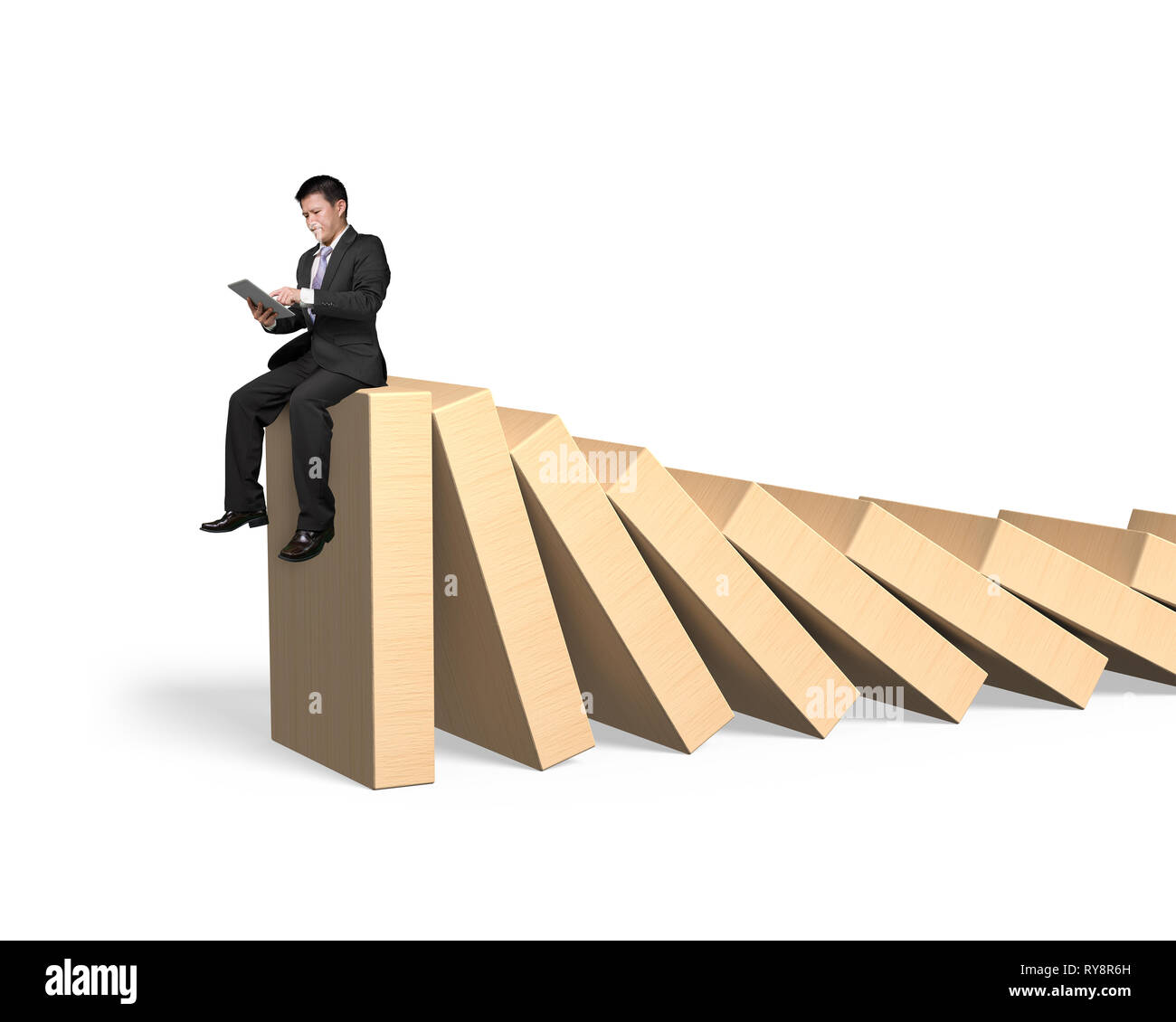 Man using smart tablet and sitting on the last piece of domino ...