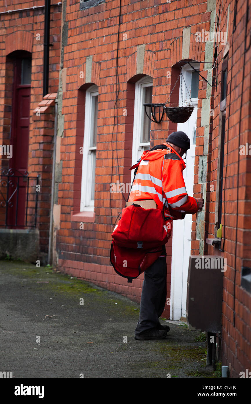 Post man delivering letters in small town in Wales Stock Photo - Alamy