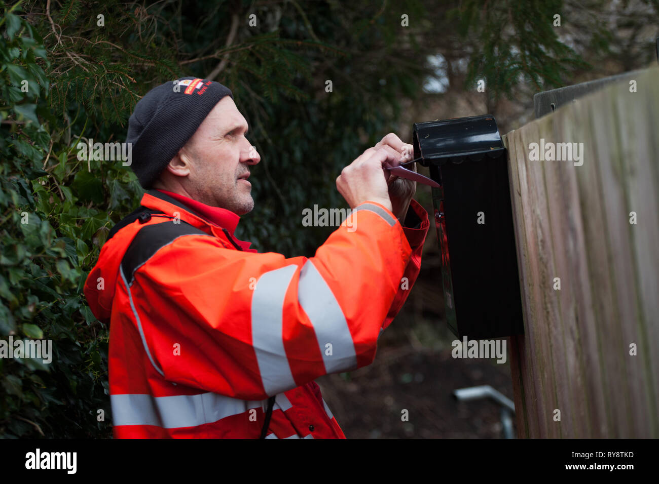 Post man delivering letters in small town in Wales Stock Photo - Alamy
