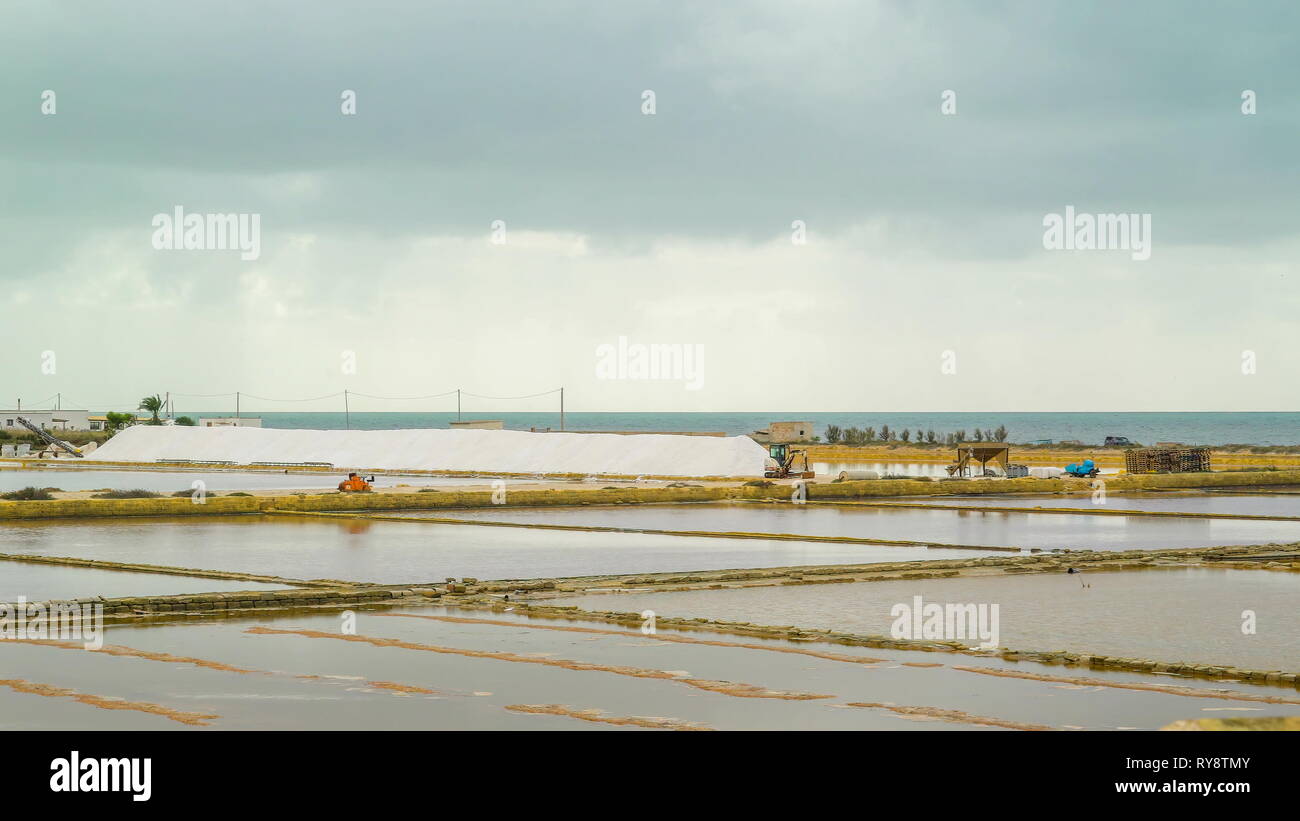 The field filled with water in saltmine in Trapani Sicily and the heap ...