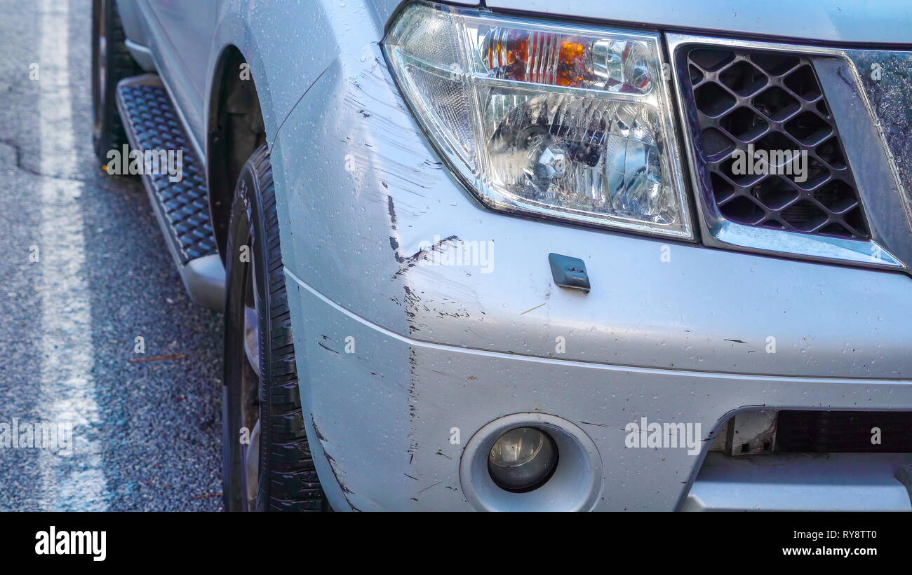 Scratch on the front near the headlights in the SUV car that is parked ...