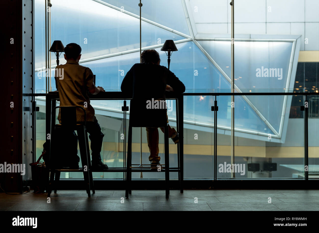 Silhouette of Man works on the workplace beside the windows on the ...
