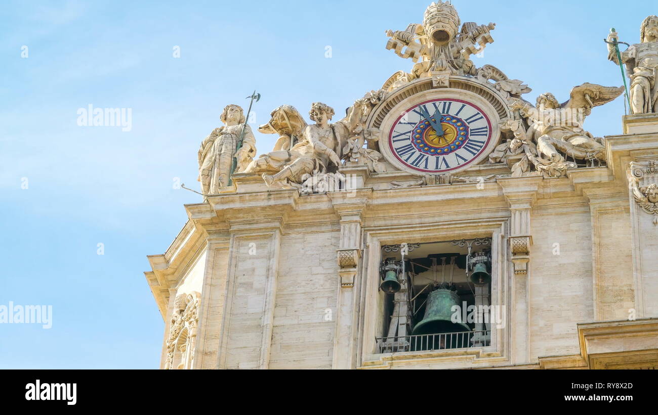 The big wall clock on the Basilica of Saint Peter in Vatican Rome Italy with the big bell below ...