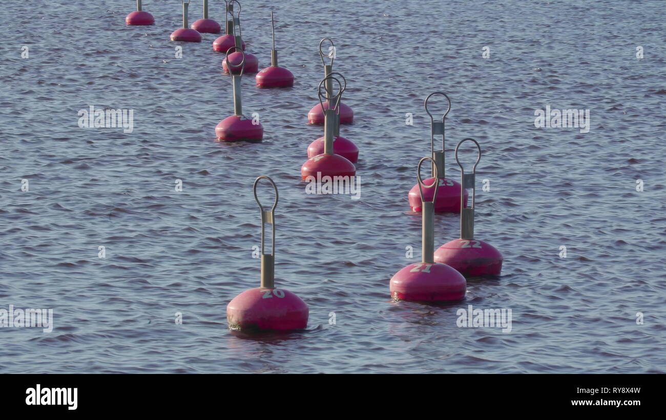 Lots of red bouys on the sea floating with the numbers on each bouy ...