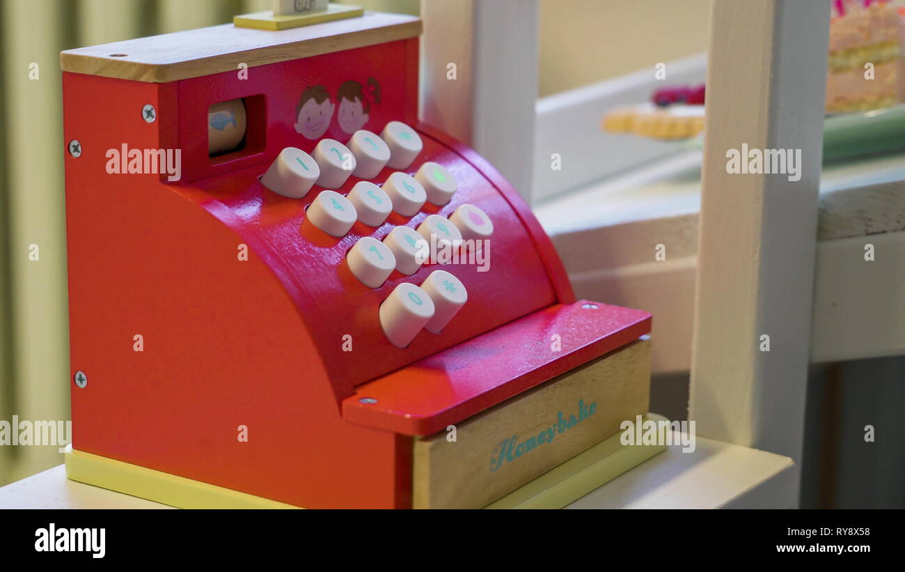 A small red cashier machine inside the toys room along with lots of ...