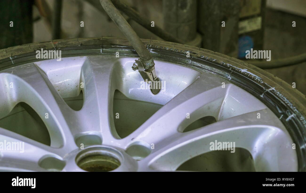 A gas hose putting air on the rubber tire inside the auto shop in the ...