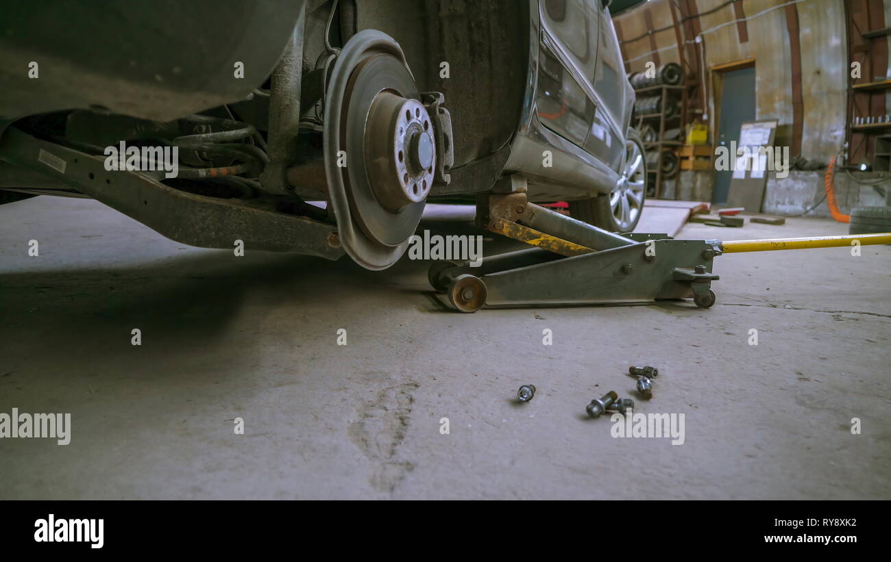 The rusty screws on the floor scattered inside the auto shop where cars ...