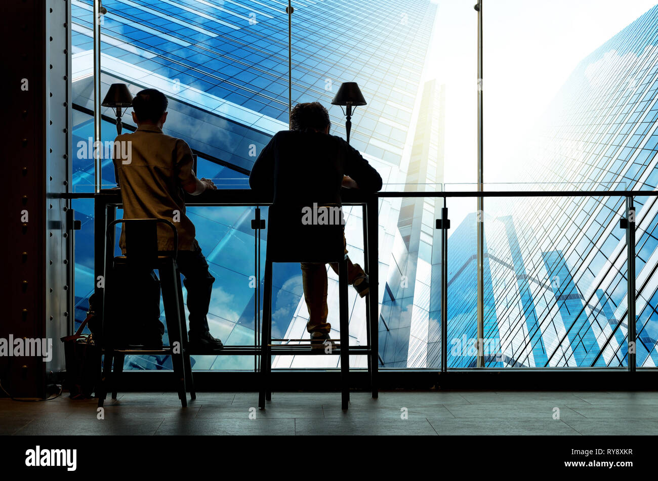 Silhouette of Man works at the workplace beside the windows with the ...
