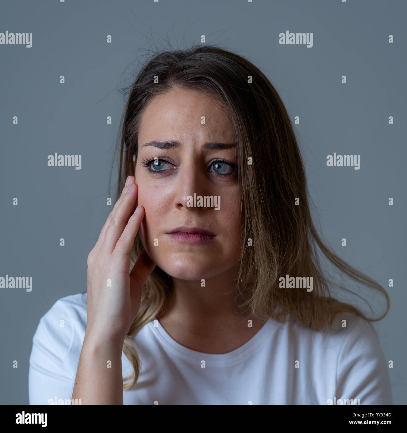 Close up portrait of beautiful young woman with sad mood looking ...