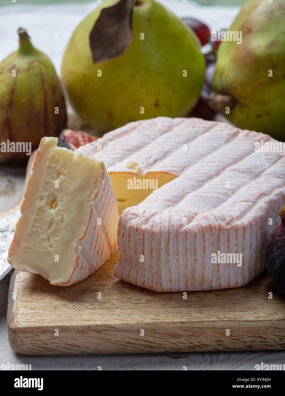 Round piece of French cheese Fleur Rouge made from cow milk served as ...