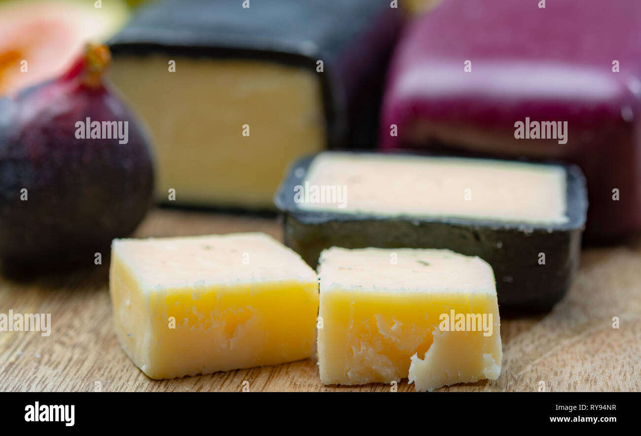 Mini black and dark red waxed cheddar cheeses made from West Country ...