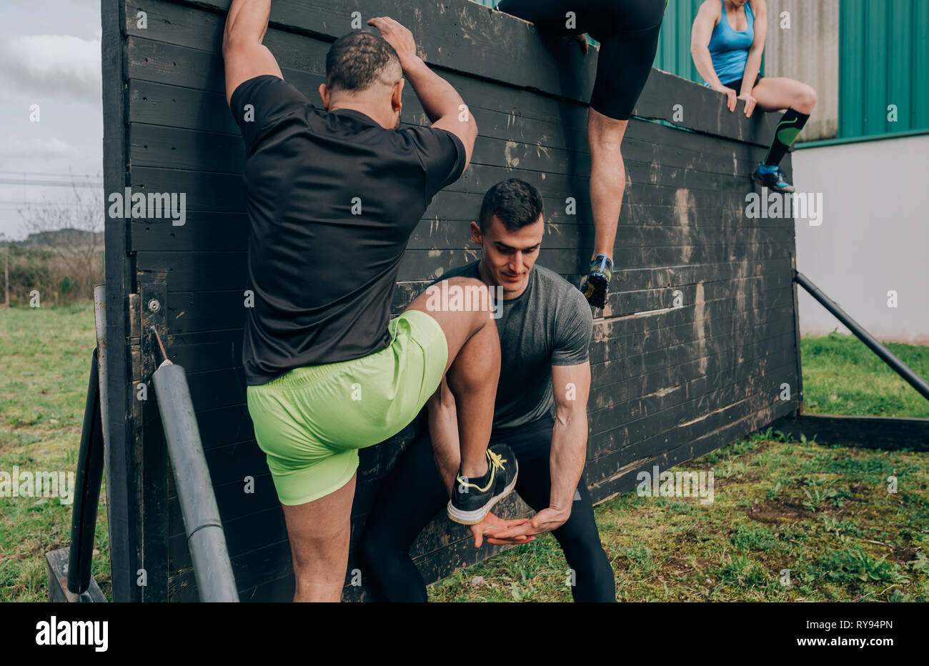 Participants in obstacle course climbing wall Stock Photo - Alamy