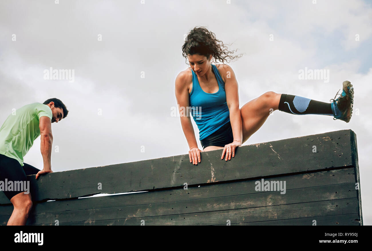 Participants in obstacle course climbing wall Stock Photo - Alamy