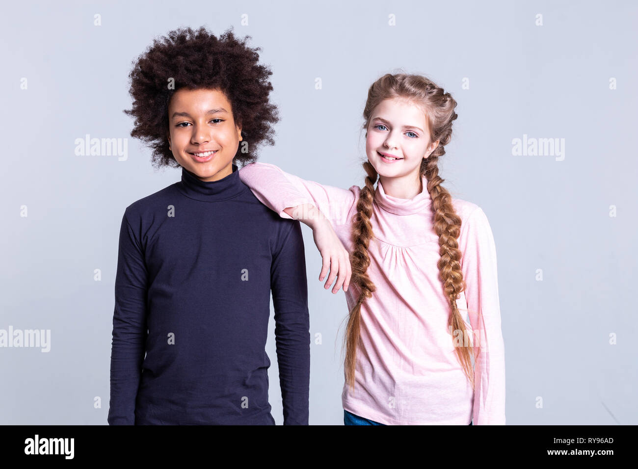 Cheerful dark-haired boy with wild haircut standing near girl Stock ...
