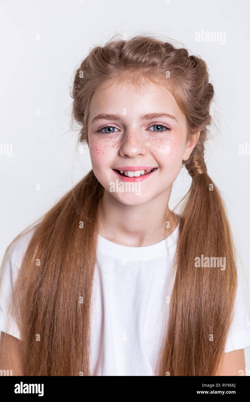 Cheerful positive pretty kid being in great mood and showing her smile ...