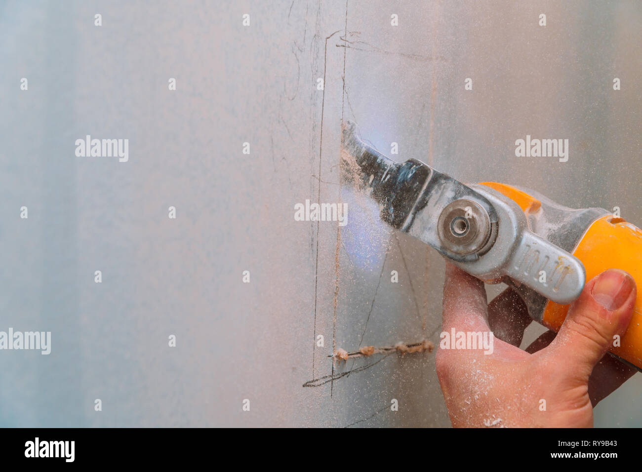 Construction worker using a sawsall tool to cut drywall a wall down to a diy house renovation cutting plasterboard drywall Stock Photo Alamy