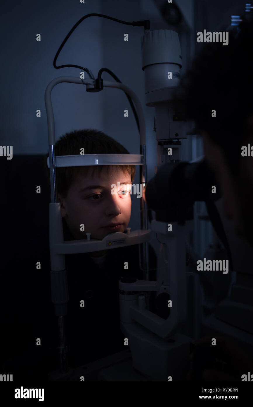 Optician testing a boy's eyes with optometry devices Stock Photo - Alamy