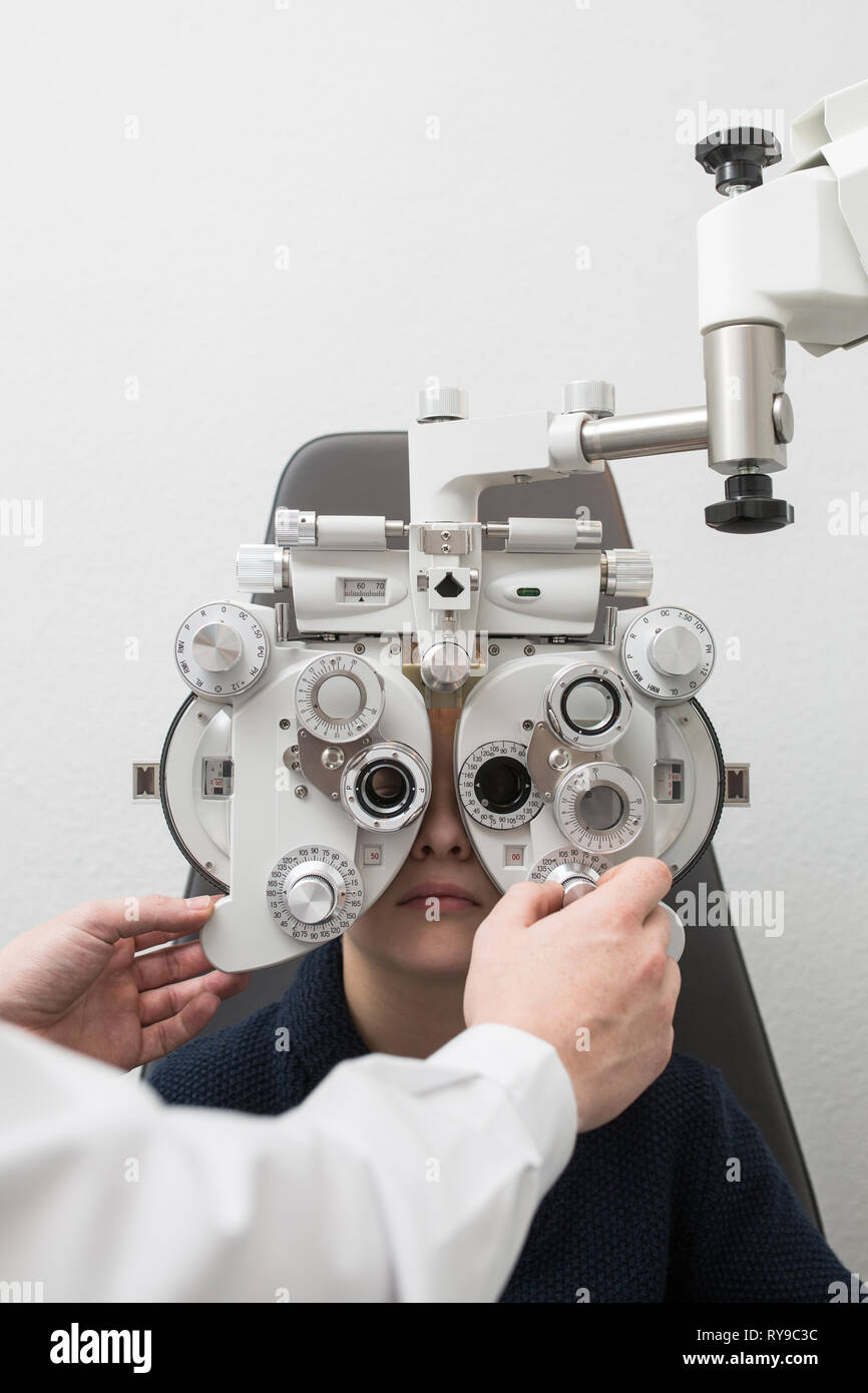 Optician testing a boy's eyes with optometry devices Stock Photo - Alamy