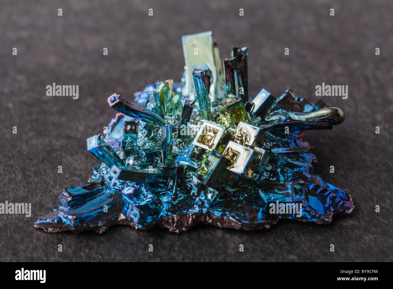 Crystal of bismuth on dark stone background Stock Photo - Alamy