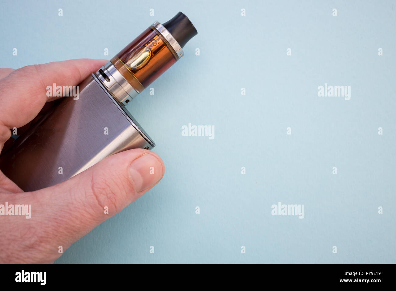 Man hand holding vape pen metal electronic cigarette with vaping blue ...