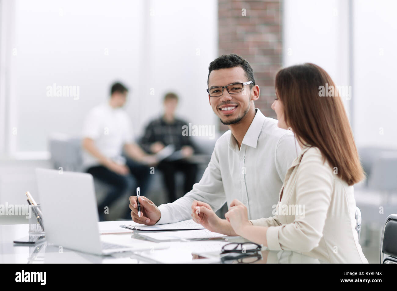 employees sitting at a table in the office Stock Photo - Alamy