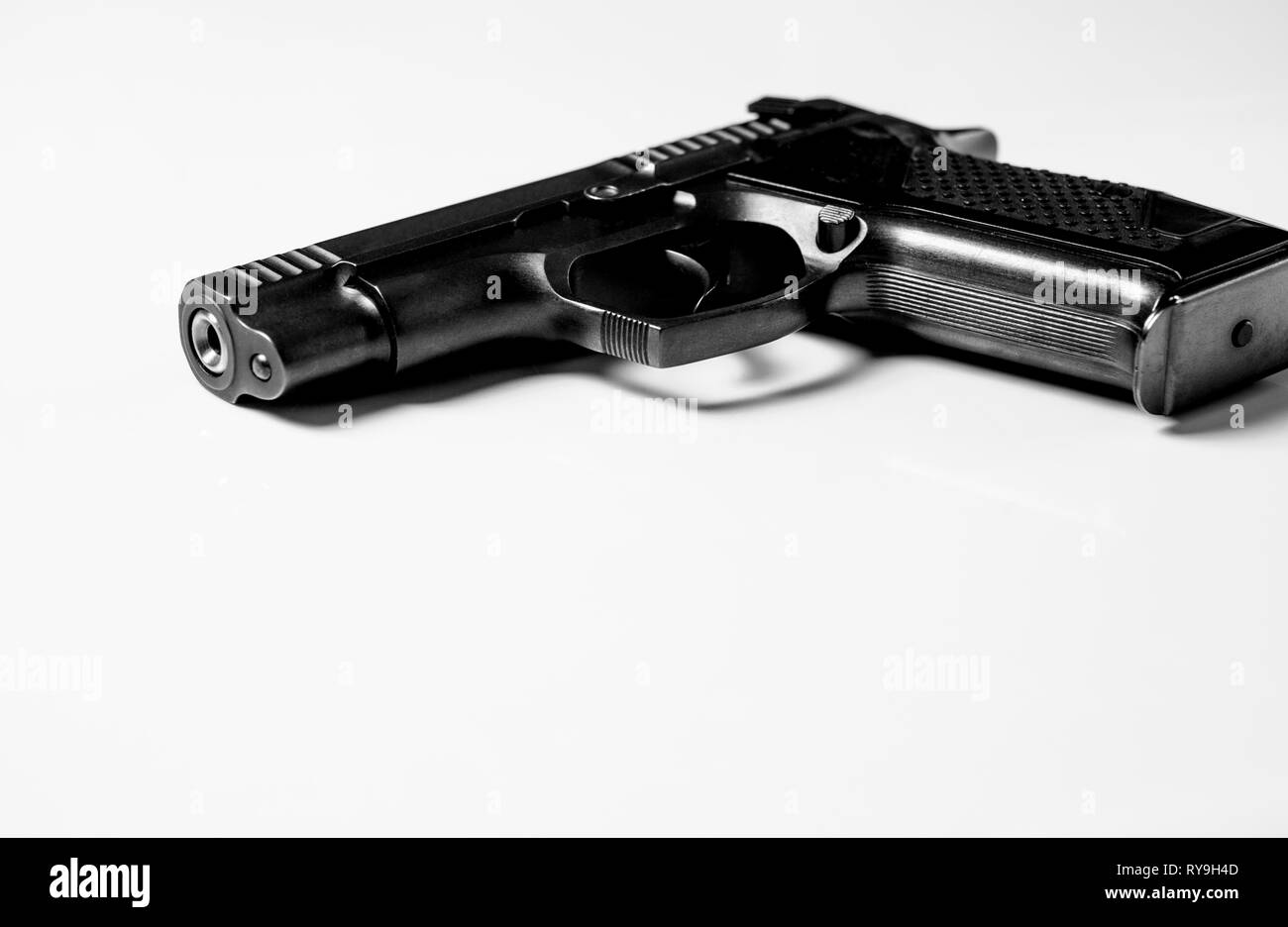 Black metal pistol lies on a white background, close-up Stock Photo - Alamy