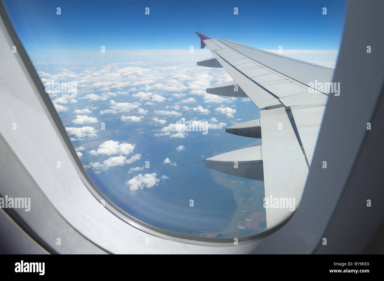 View of clouds and land from airplane window Stock Photo - Alamy