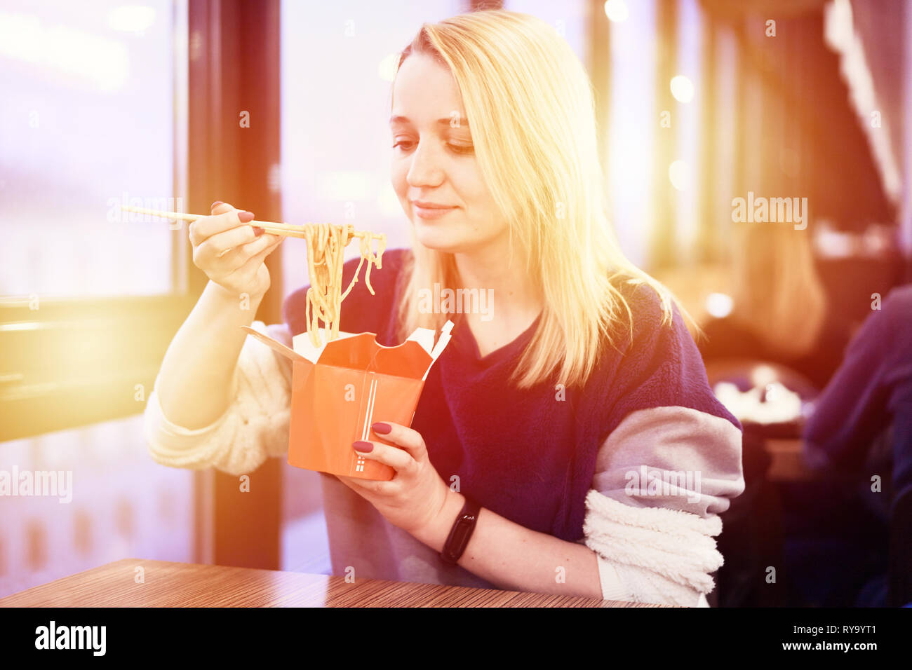 Girl eat wok on food kurt. Beautiful woman eating thai noodles in paper ...