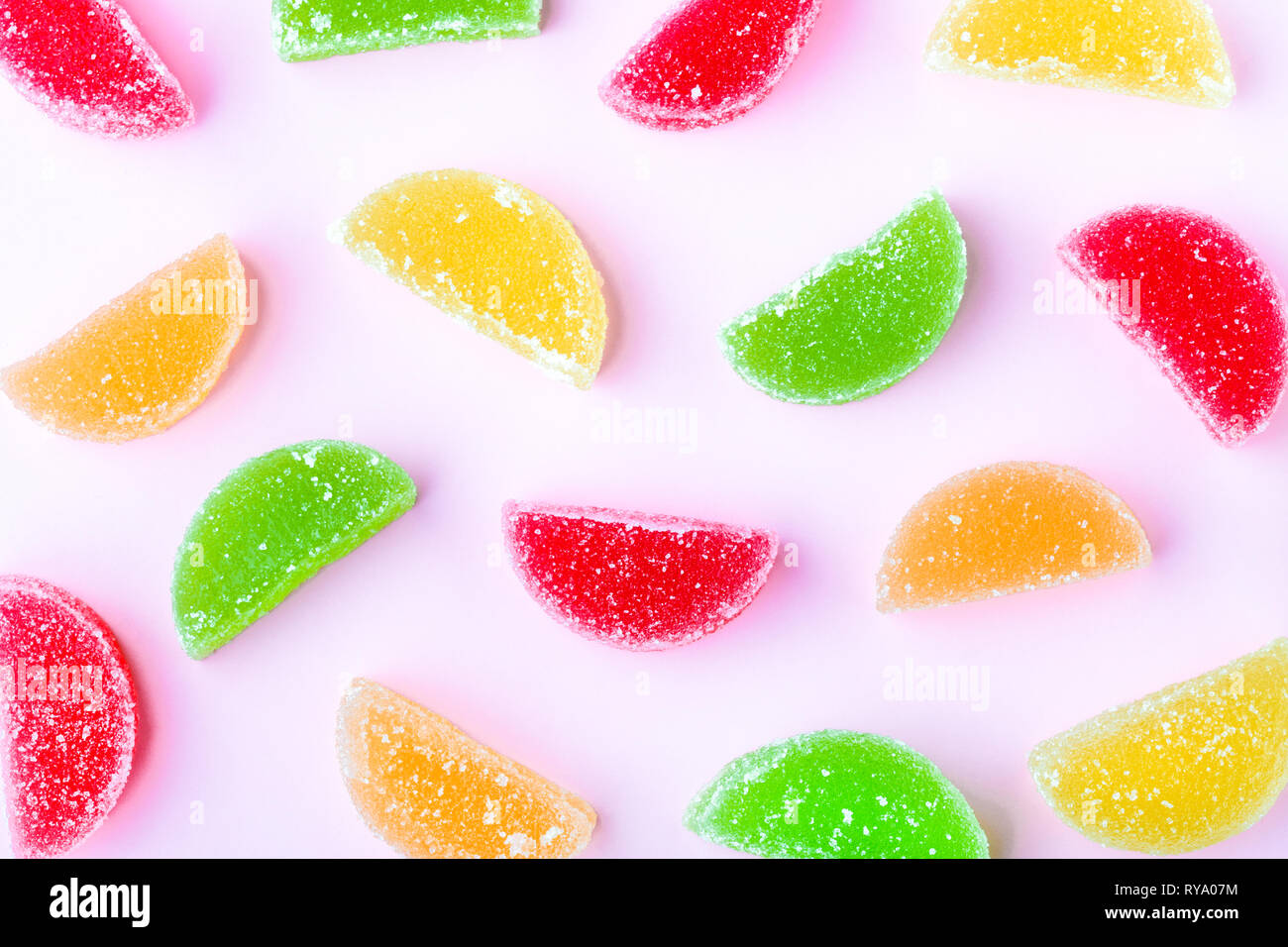 colored fruit jelly with sugar crystals, on a pink background Stock ...