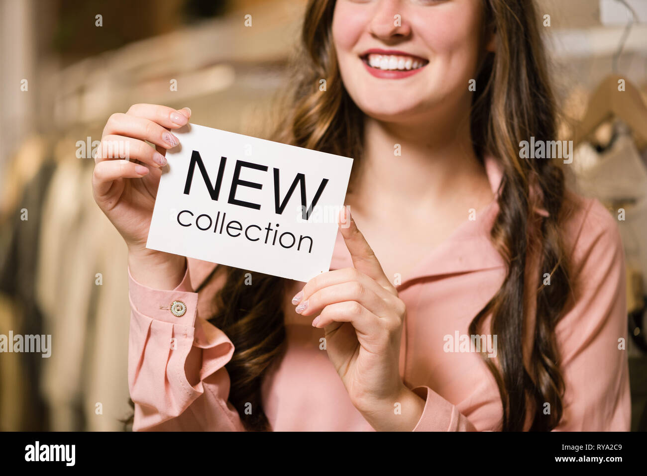 Smiling brunette woman holds new collection words Stock Photo - Alamy