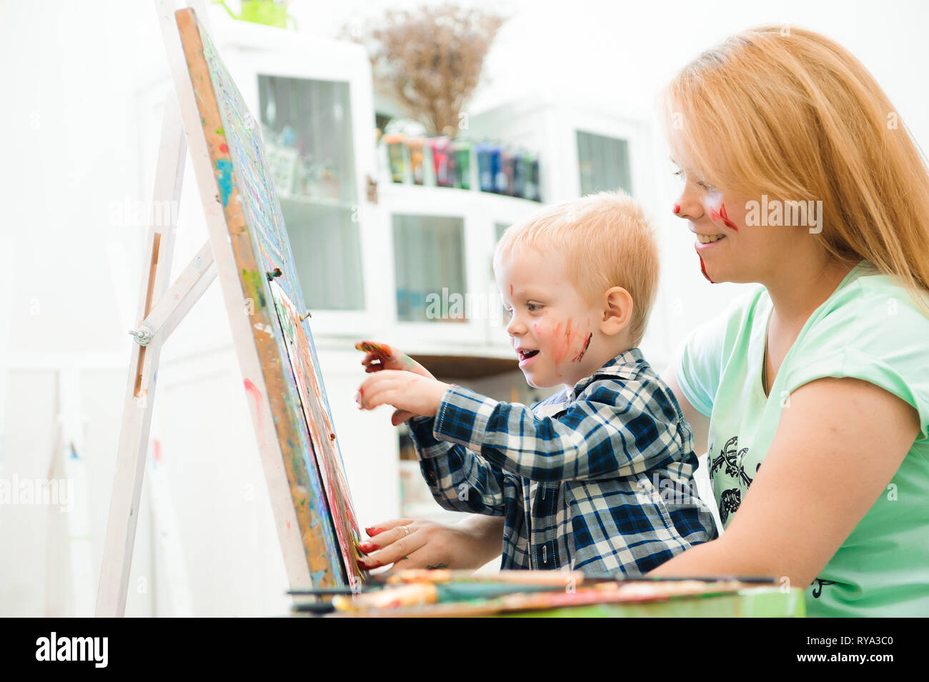 Mother and child draw a picture paints, art lesson Stock Photo - Alamy