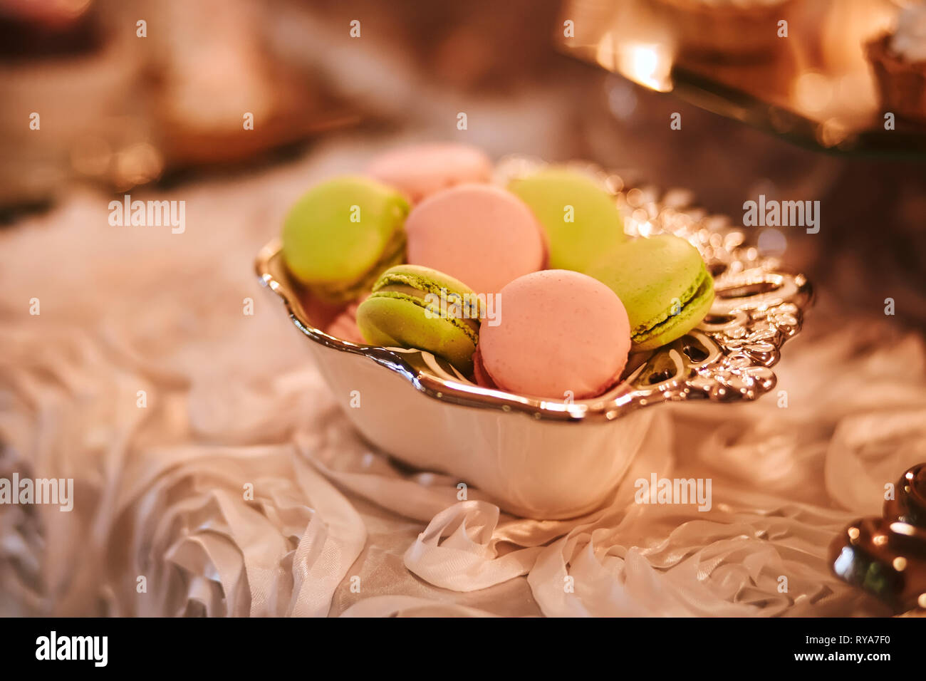 Colorful macarons stand in round transparent weight as part of candy ...