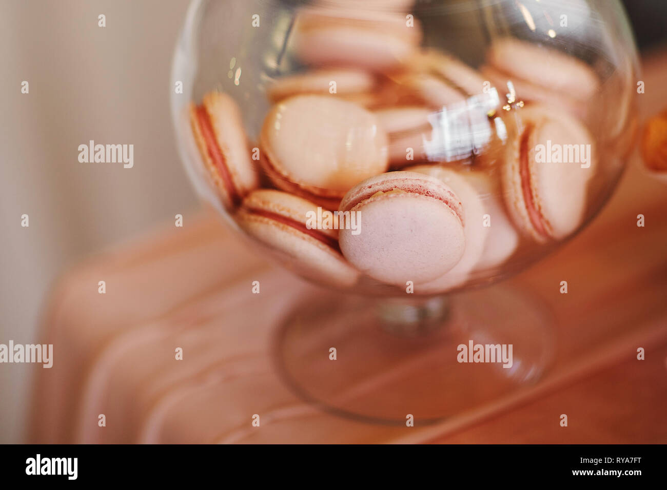 Colorful macarons stand in round transparent weight as part of candy ...