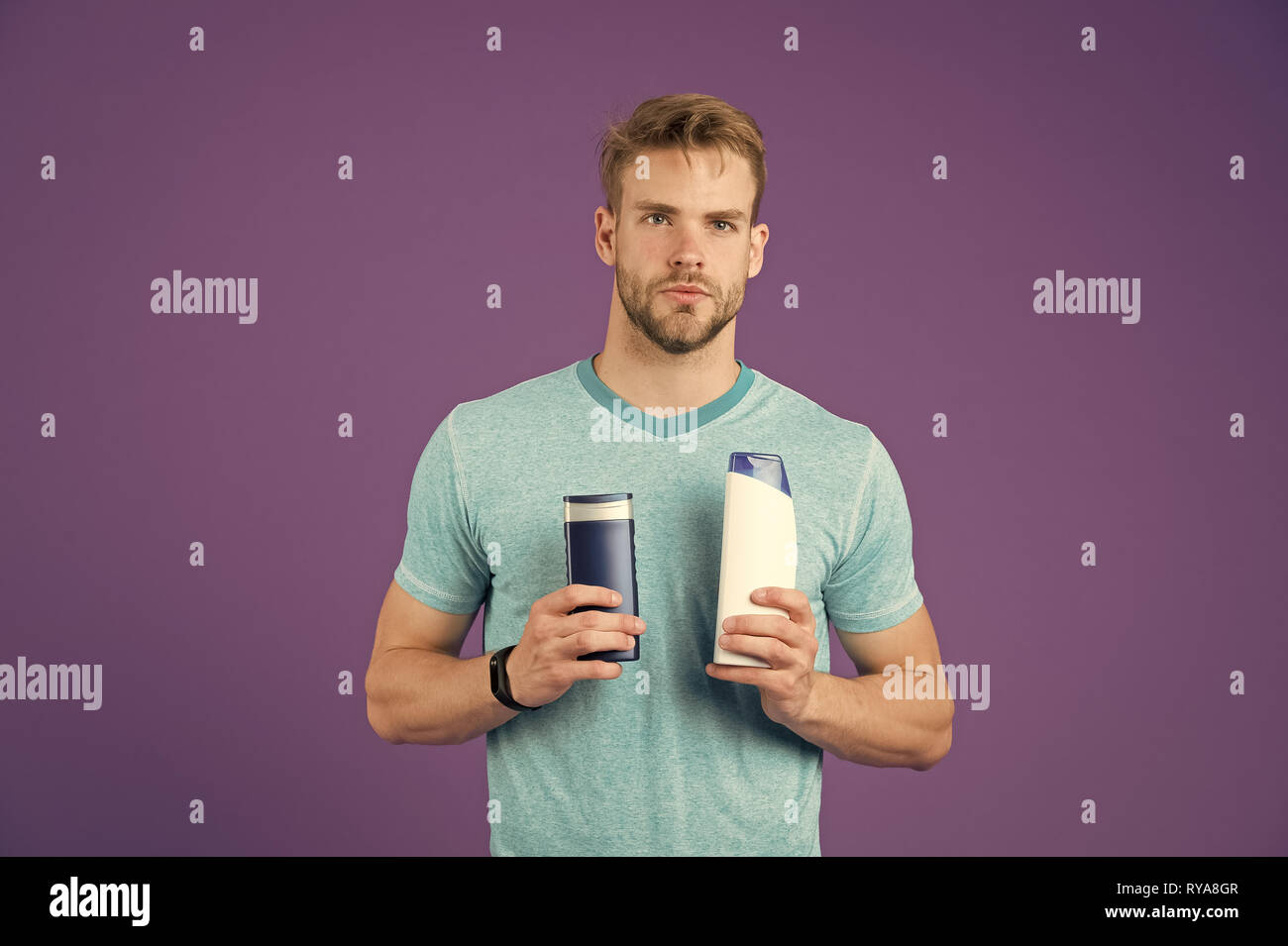 Make your choice. Man stylish hairstyle holds two bottles hygienic ...